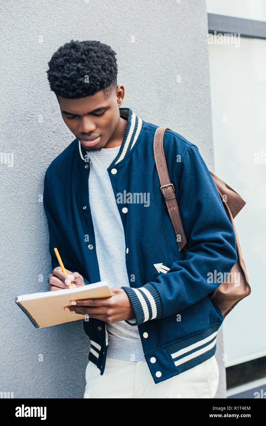 stylish focused african american student writing in textbook Stock ...