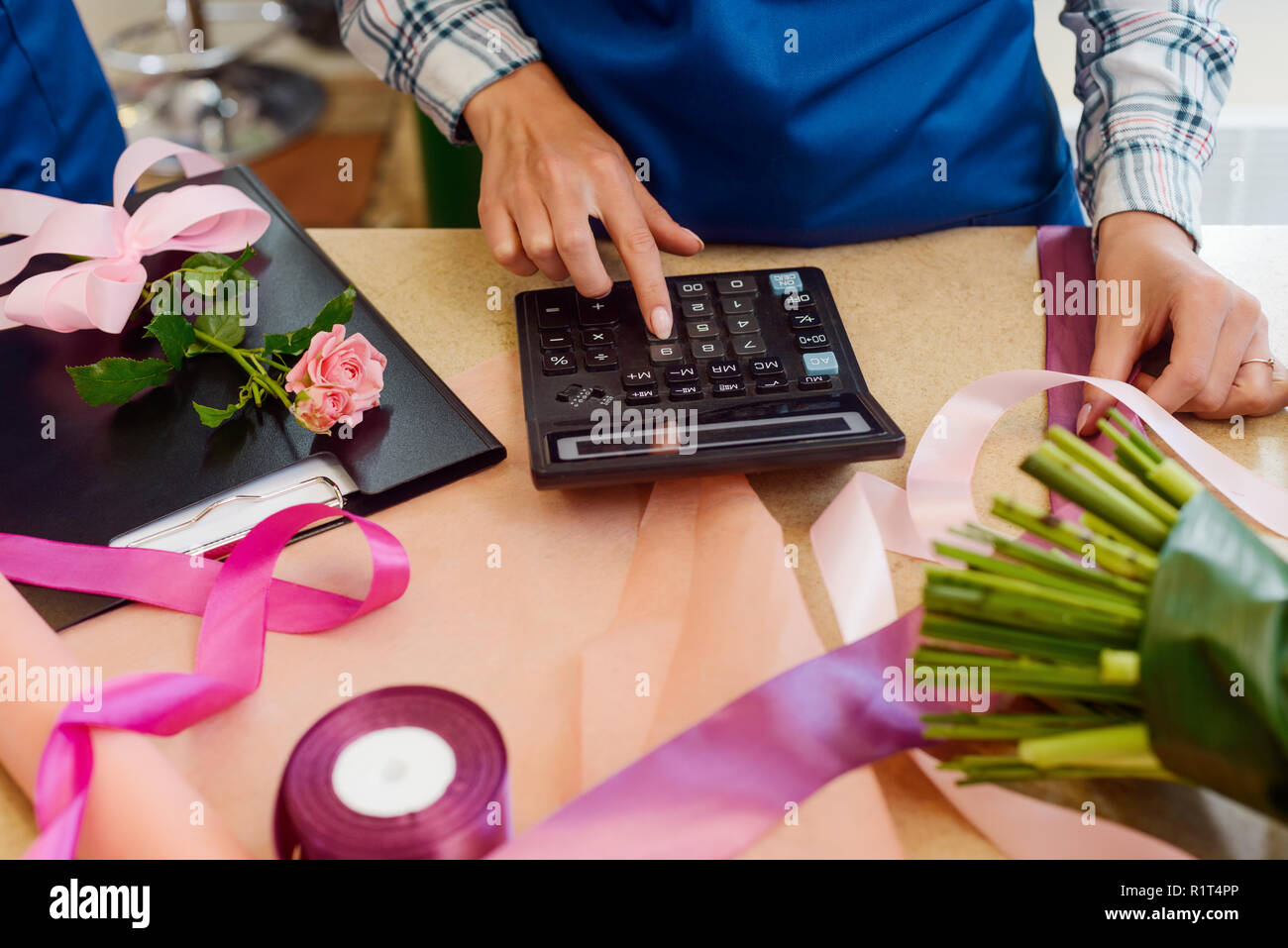 Cashier counting payment on calculator Stock Photo - Alamy