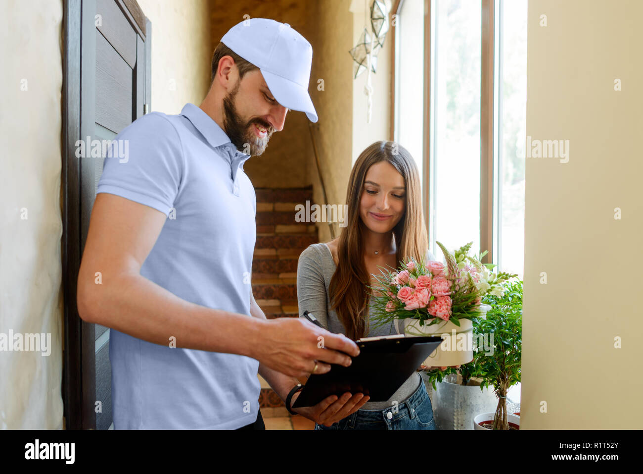 Woman signing a delivery receipt Stock Photo - Alamy