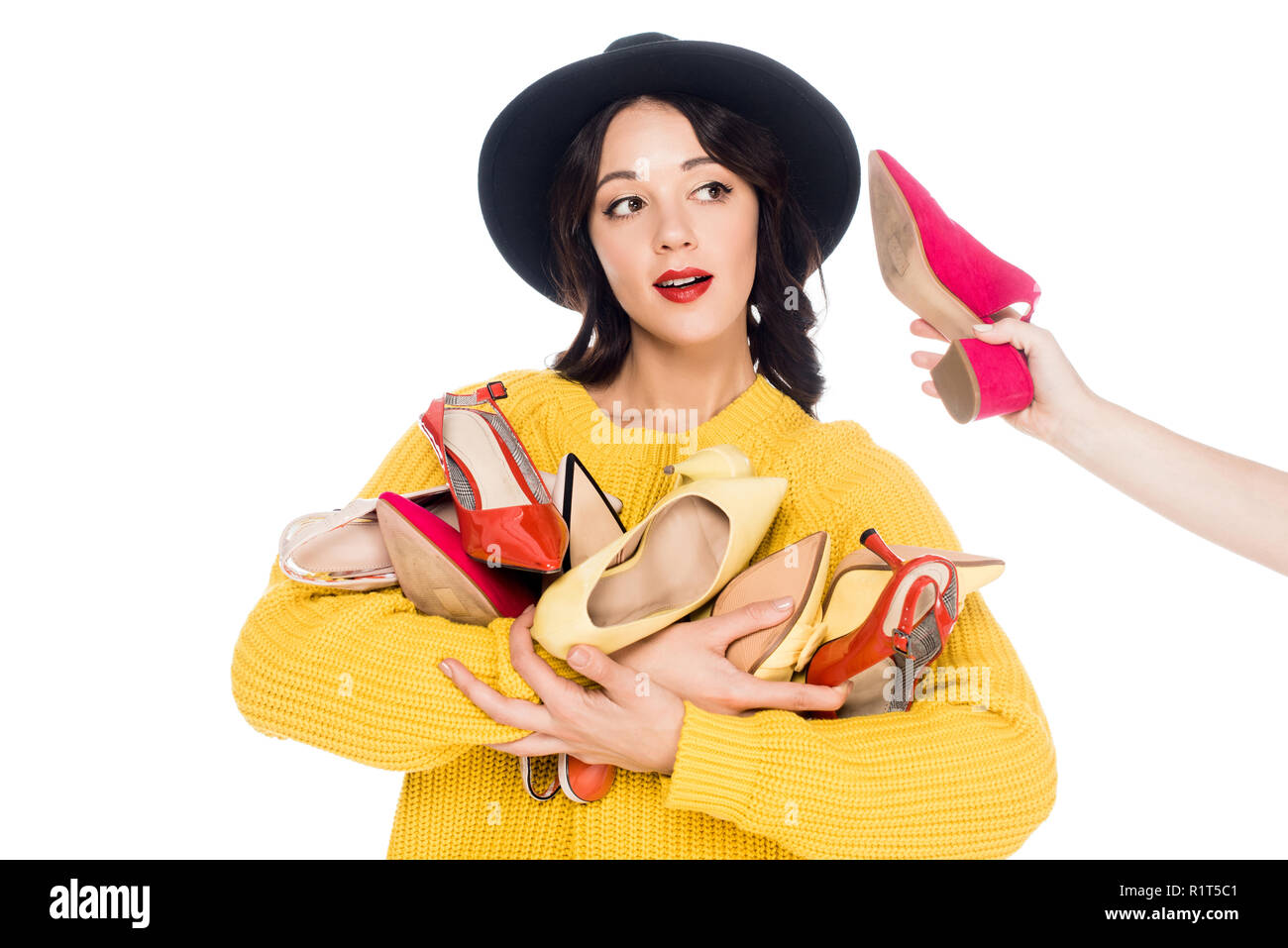 beautiful fashionable girl with shoe near ear holding heap of high ...