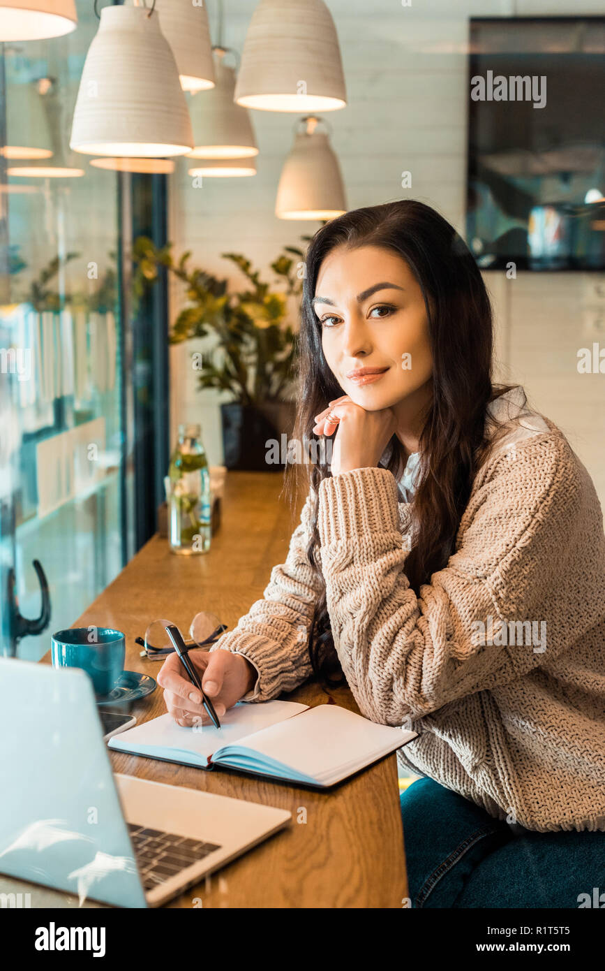 beautiful female freelancer working with planner and laptop in cafe ...