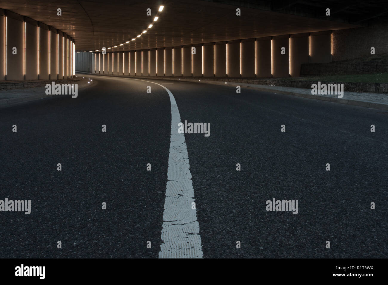 Curved lit road tunnel Stock Photo - Alamy