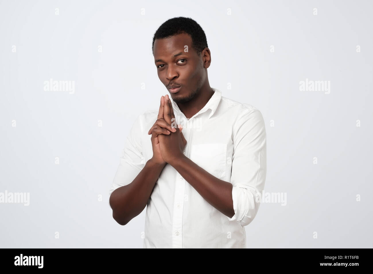 Confident african male student in white shirt makes shooting gesture ...
