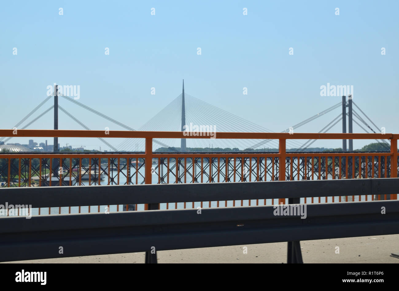 Pillars of bridges on a river seen through fences of another bridge ...