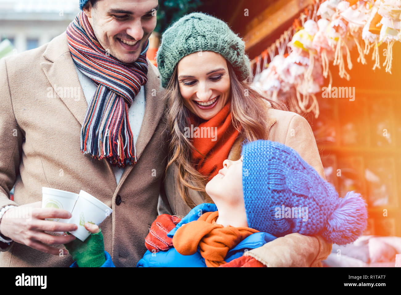 Family standing on traditional Christmas market in front of gift stall ...