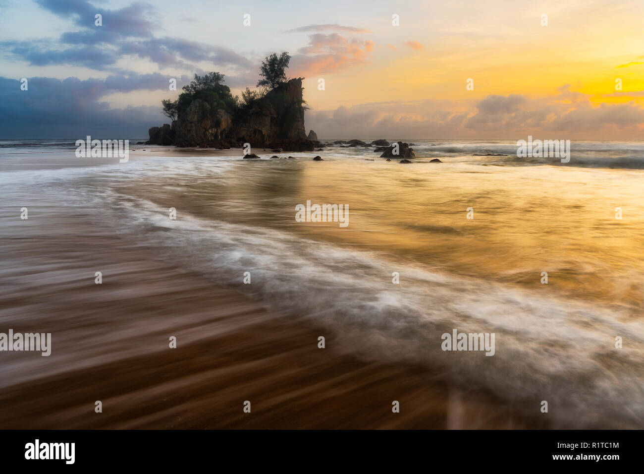 Low angle shot of waves crashing the beach during sunrise with the ...