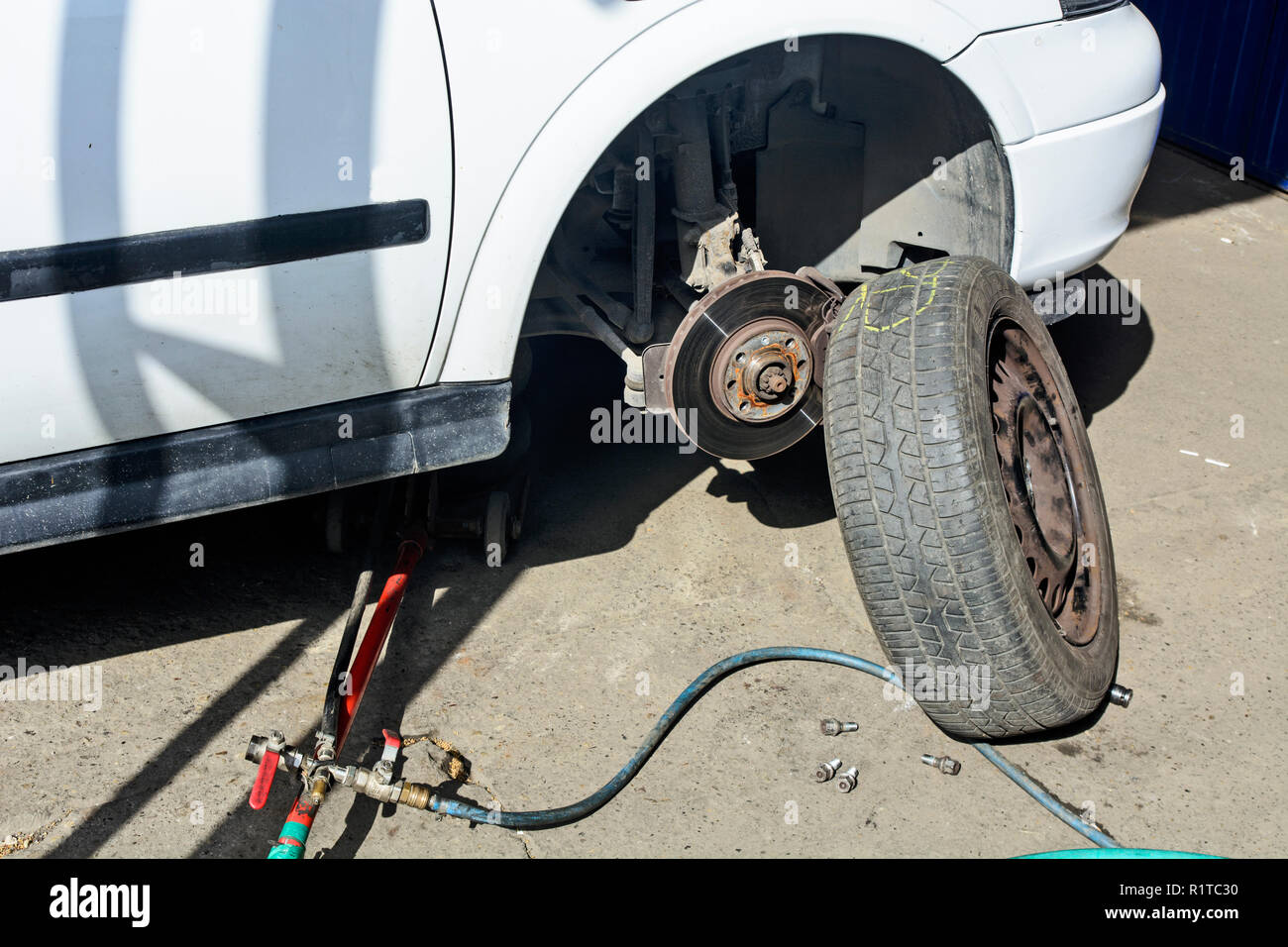 Changing the wheels on the car that stands in front of a workshop Stock ...