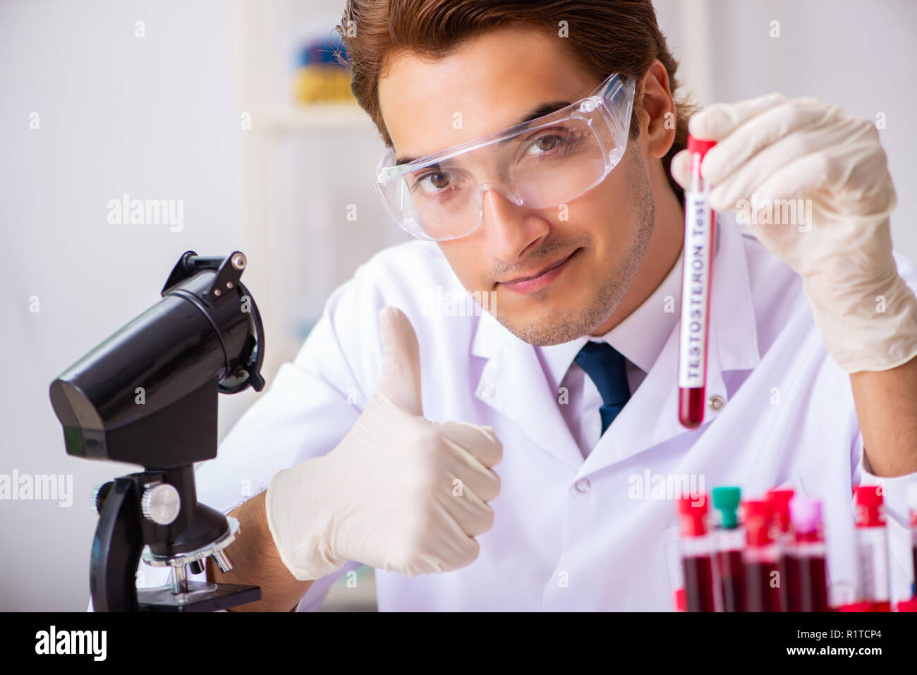 Young handsome lab assistant testing blood samples in hospital Stock ...