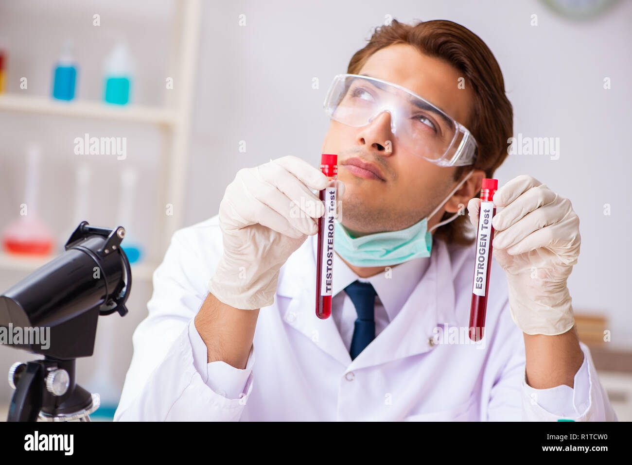 Young handsome lab assistant testing blood samples in hospital Stock ...
