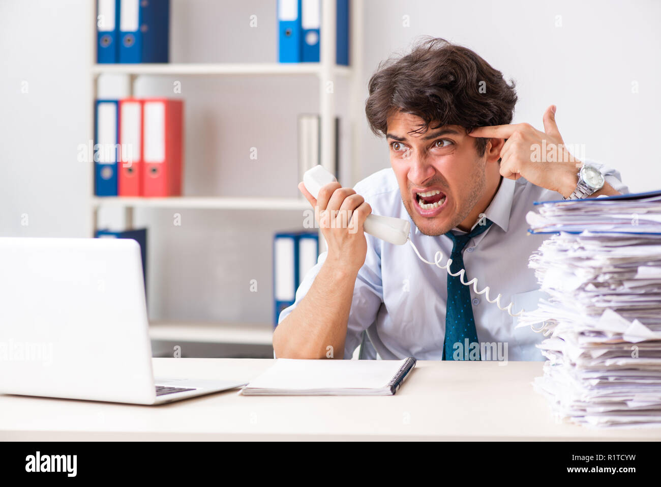 Overloaded busy employee with too much work and paperwork Stock Photo ...