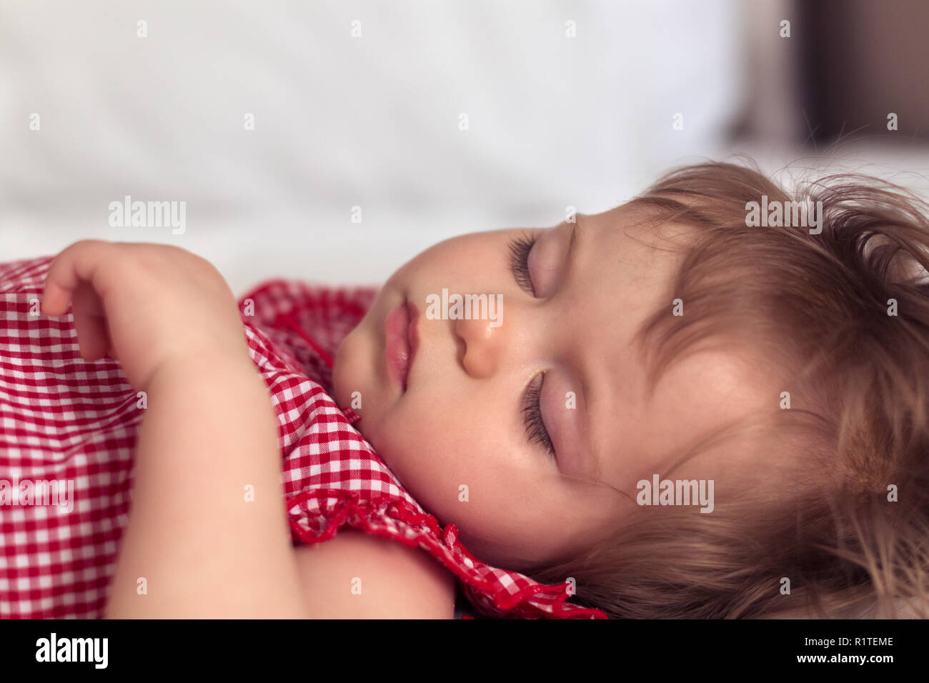 Close up portrait of a beautiful nine month old baby girl sleeping on ...