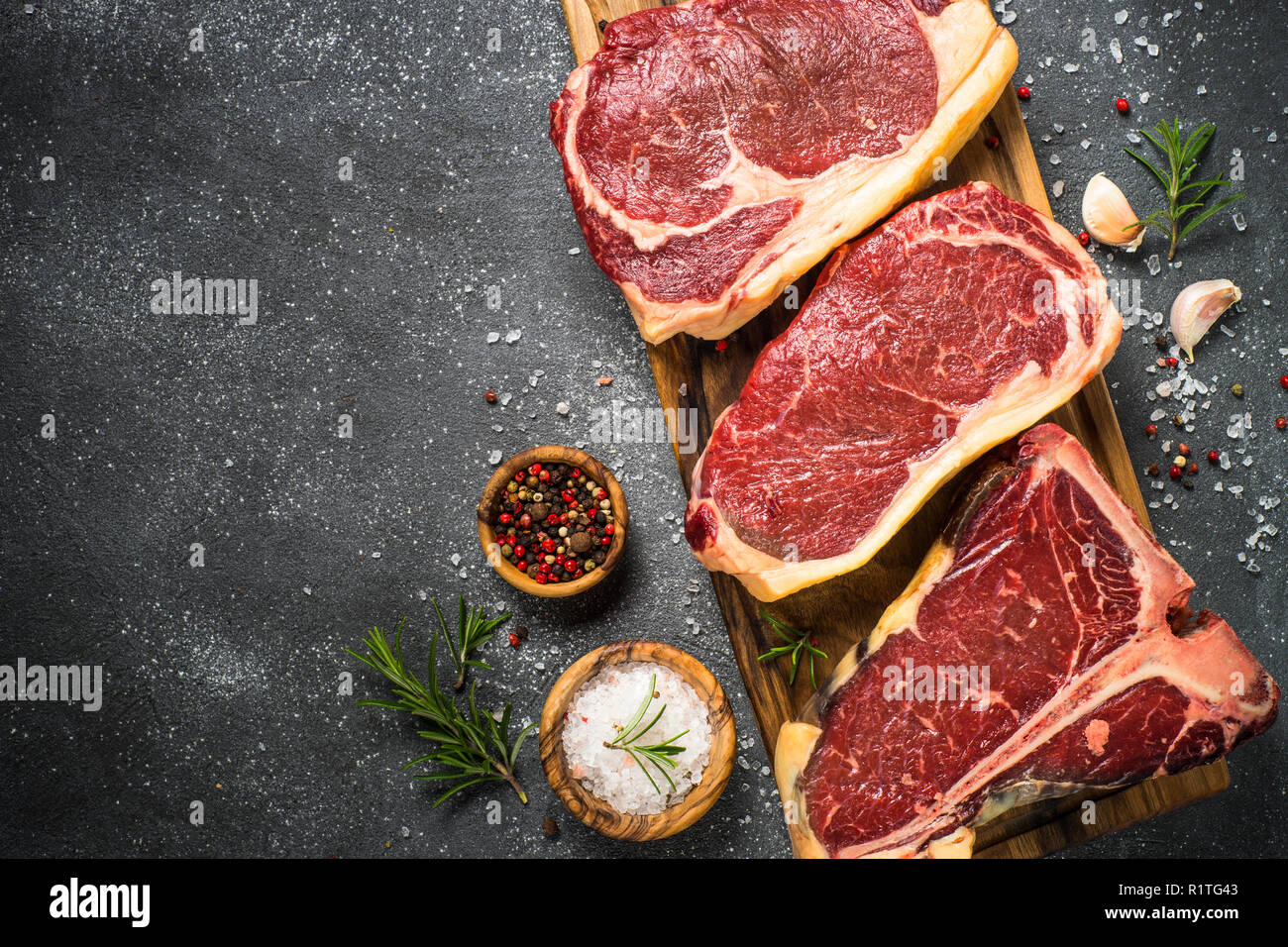 Raw meat beef steak on black top view Stock Photo - Alamy