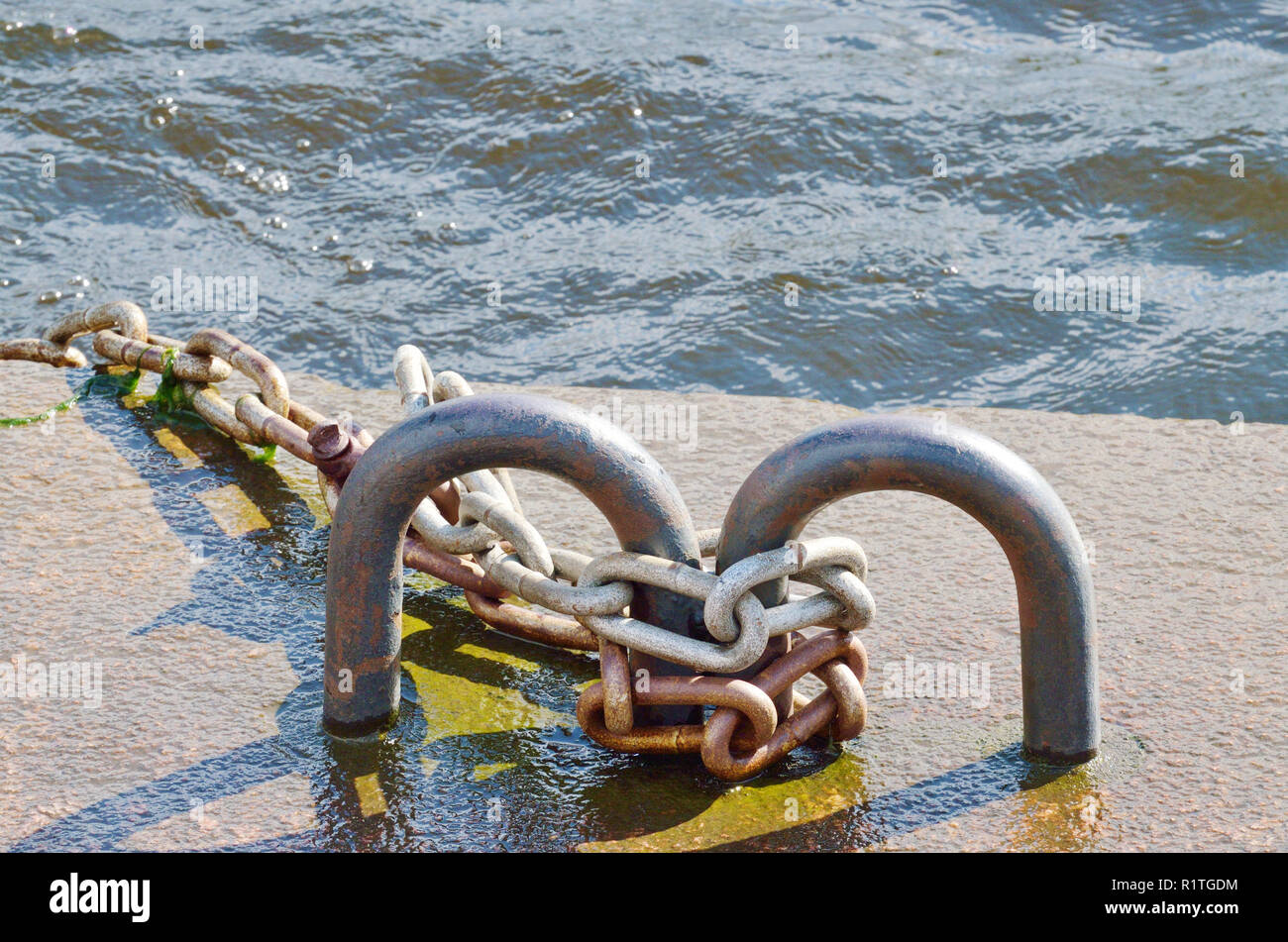 Iron chain on the pier of the river.They keep the boat near the shore ...