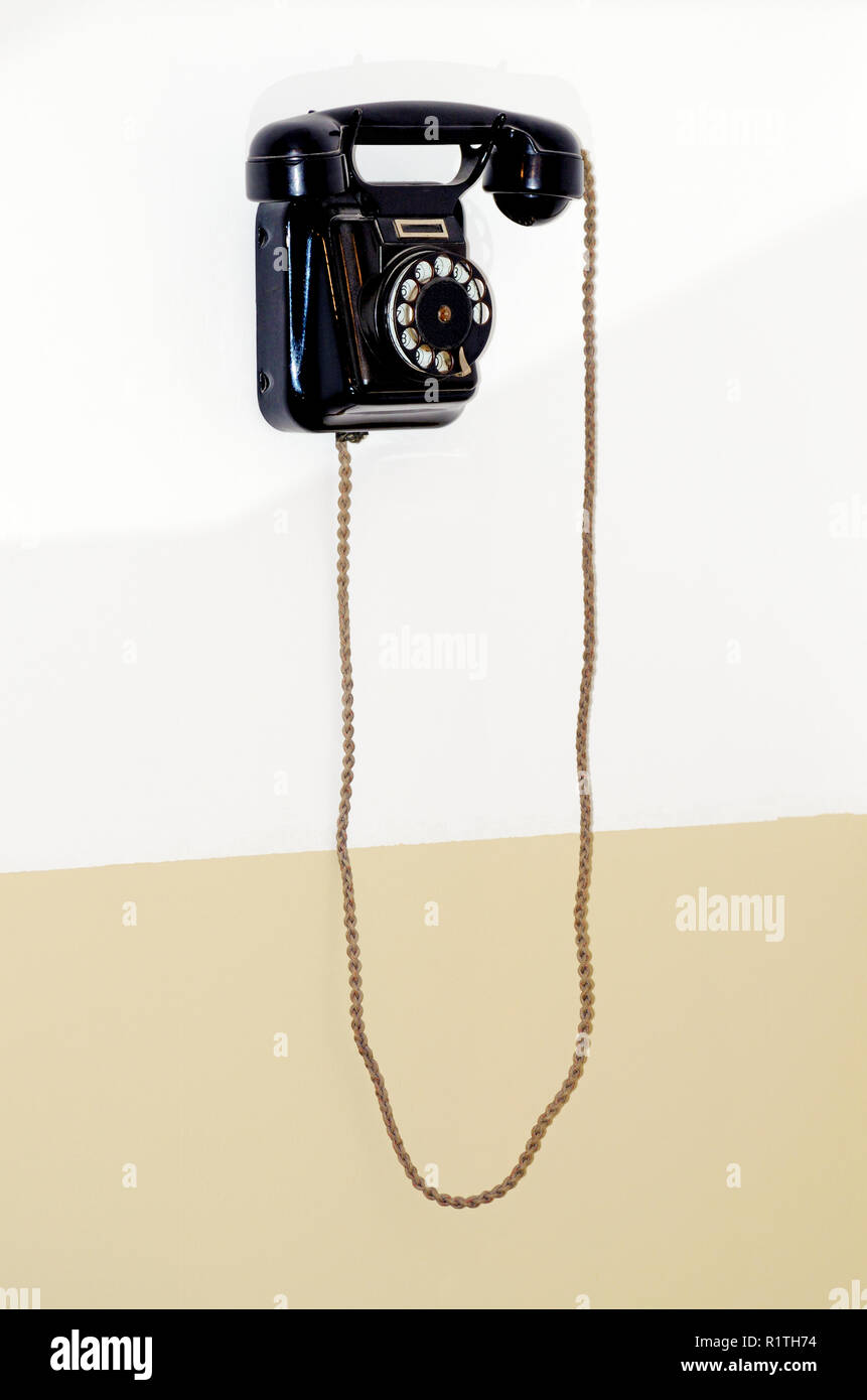 Vintage phone hanging on the wall.The device serves as a means of ...