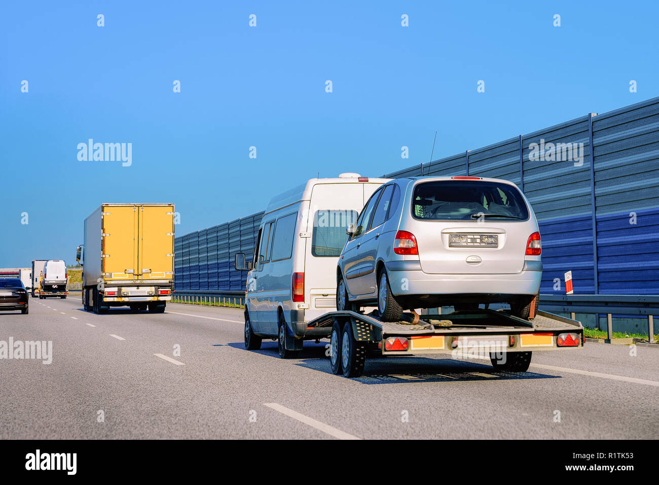 Car carrying trailer with new vehicles at the asphalt road of Slovenia ...