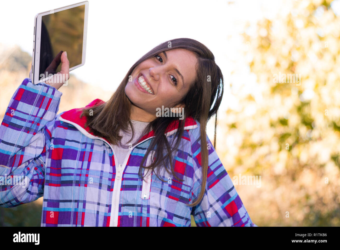 Happy brunette caucasian young girl catching her cheerful tablet in ...