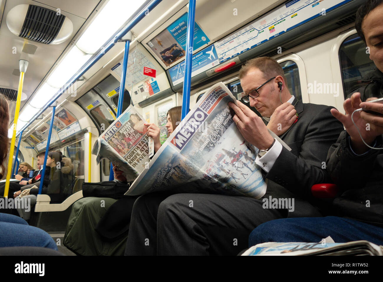 Man on subway train newspaper hi-res stock photography and images - Alamy