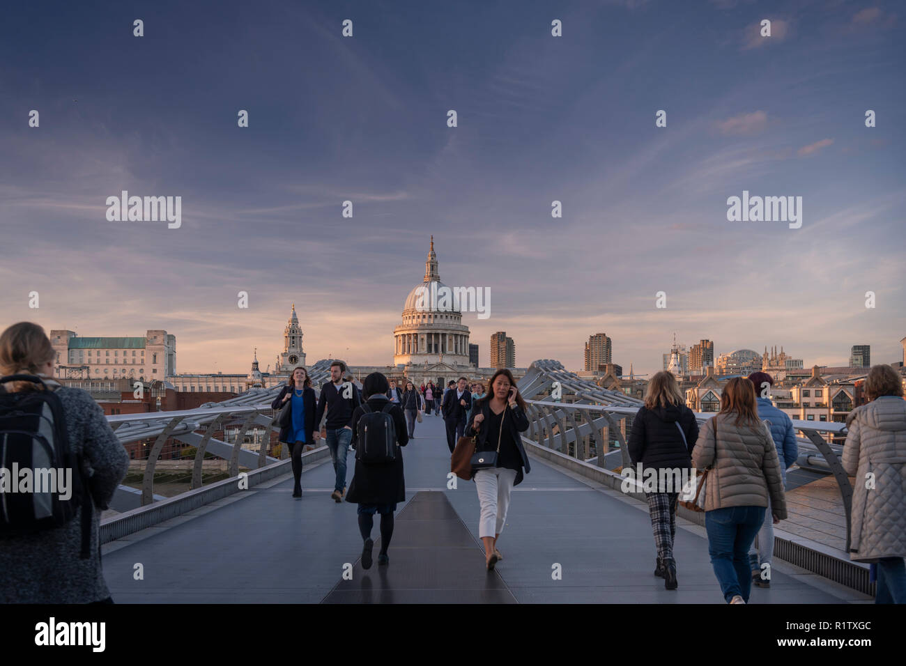 People walking over the Millennium Bridge with St. Paul's Cathedral in ...