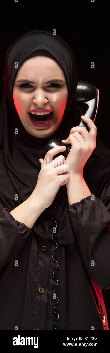 Portrait of beautiful serious scared young muslim woman wearing black ...