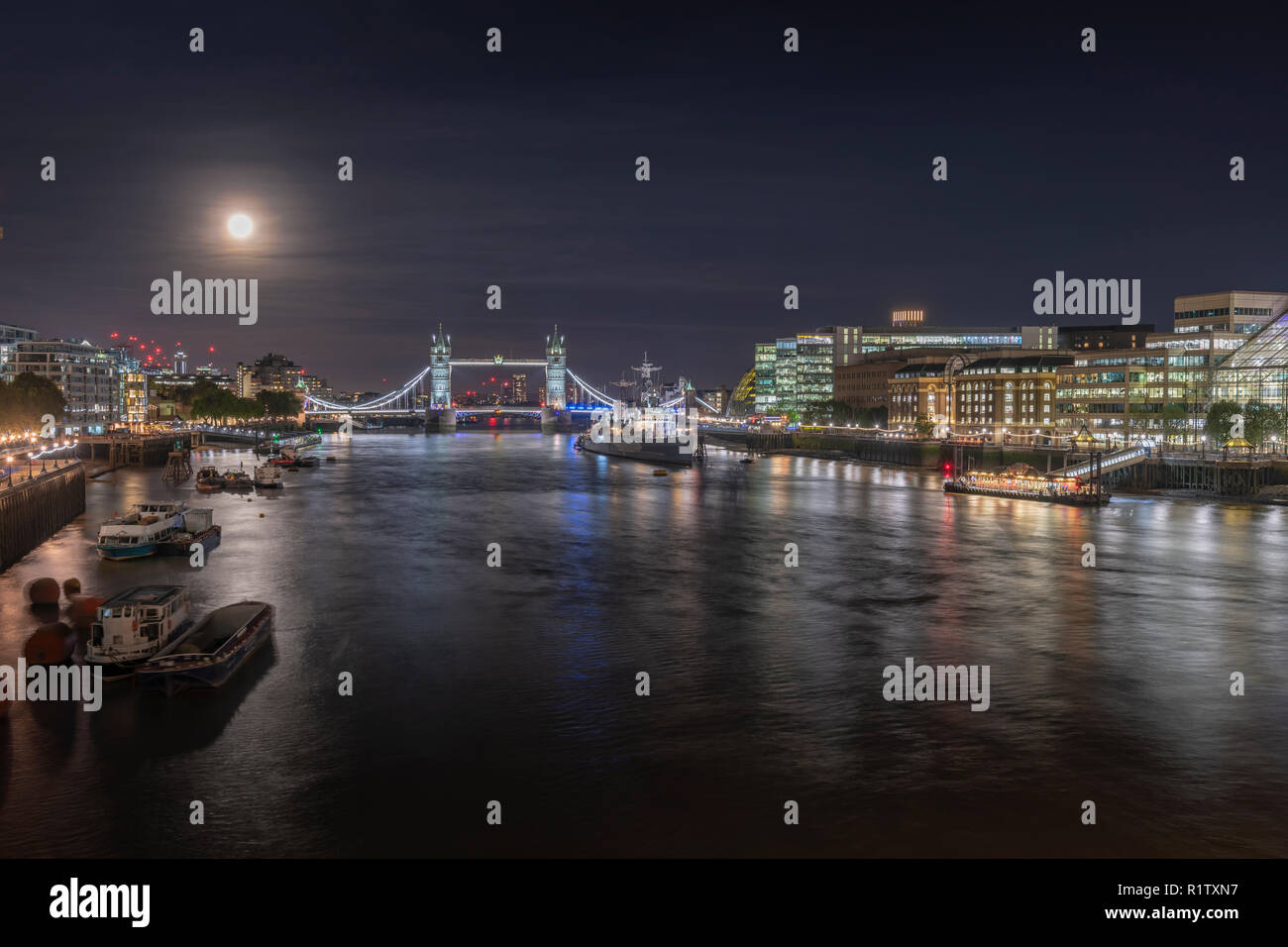 Tower Bridge at night with HMS Belfast and a full moon Stock Photo - Alamy