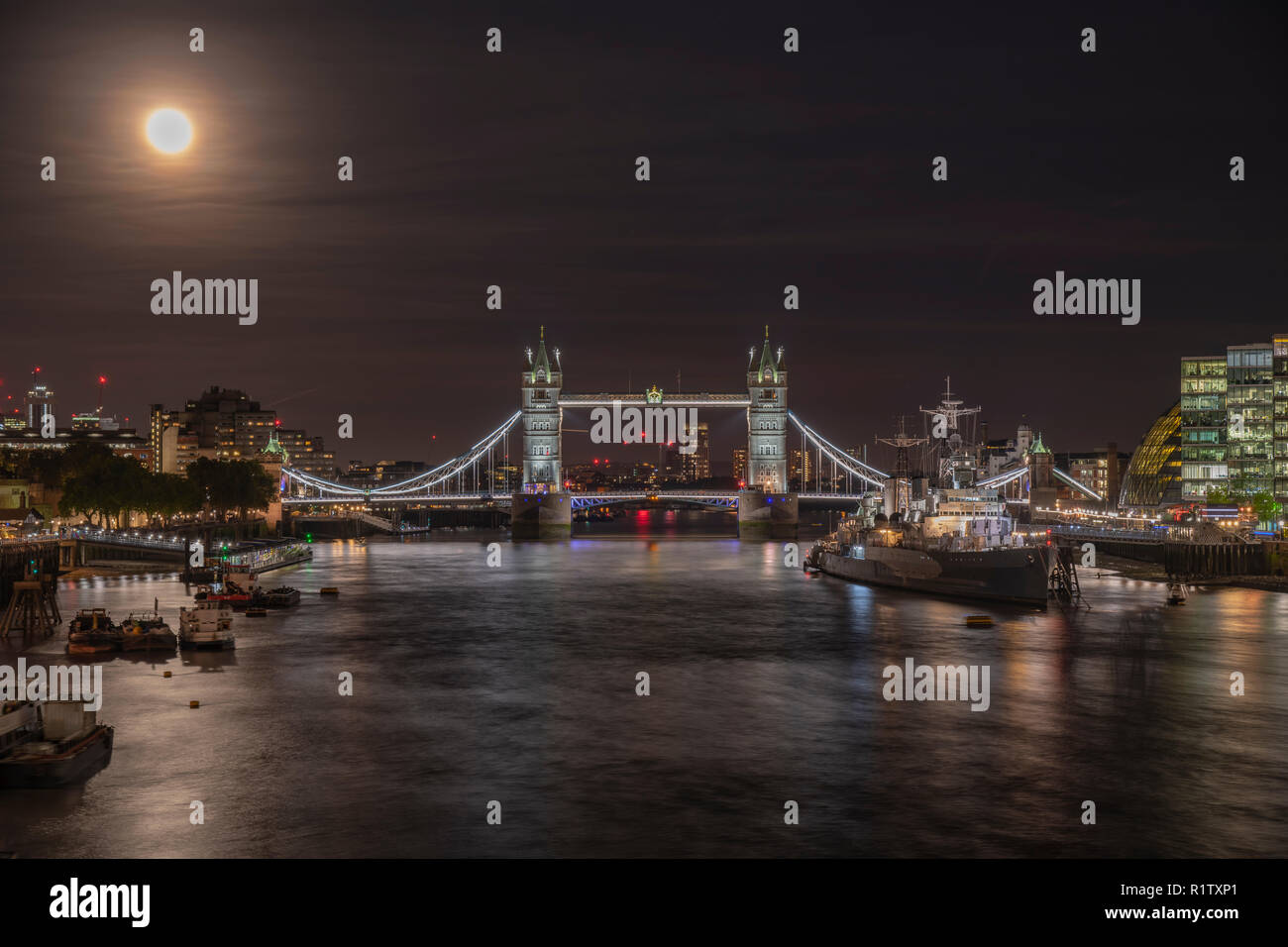 Tower Bridge at night with HMS Belfast and a full moon Stock Photo - Alamy