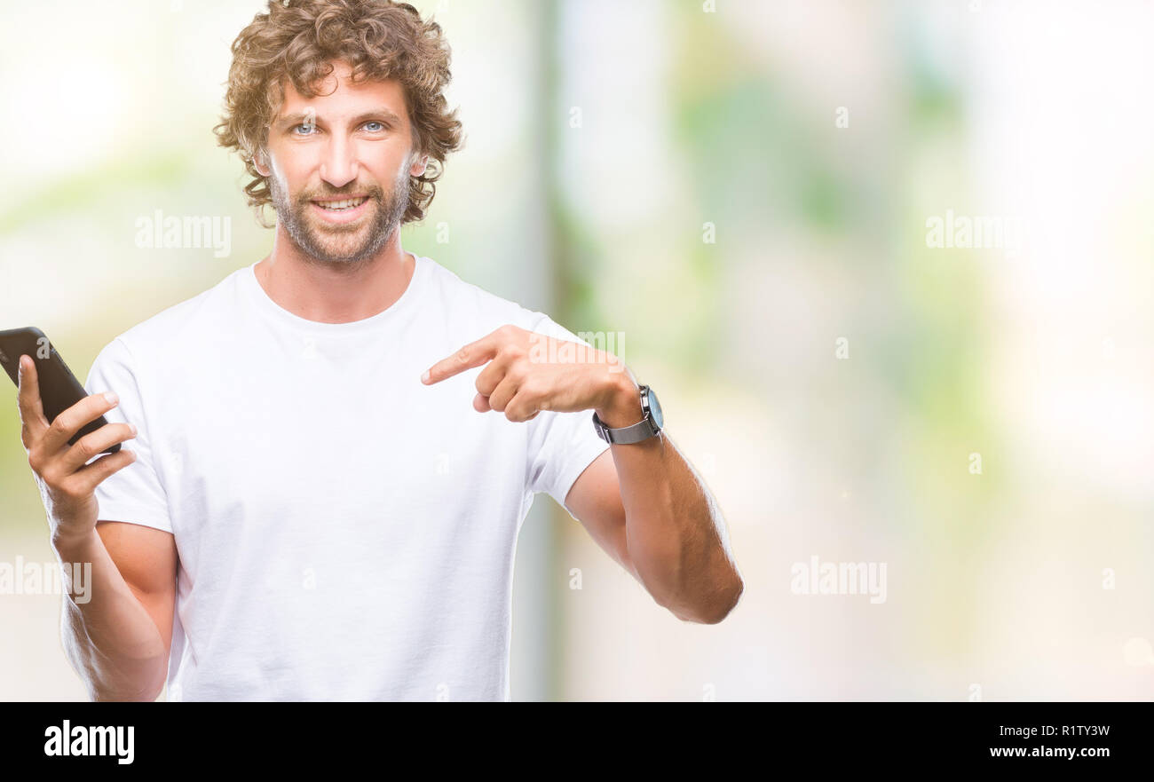 Handsome hispanic man model sending message texting using smartphone ...