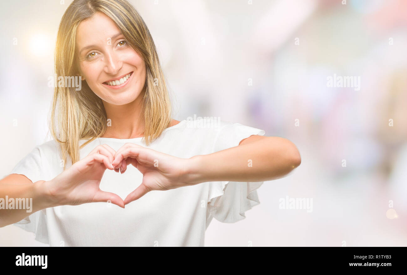 Young beautiful woman over isolated background smiling in love showing ...