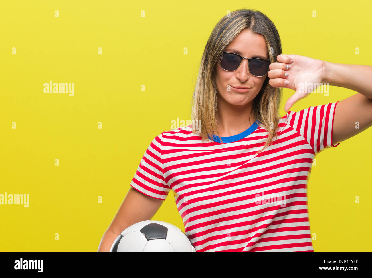 Young beautiful woman holding soccer football ball over isolated ...