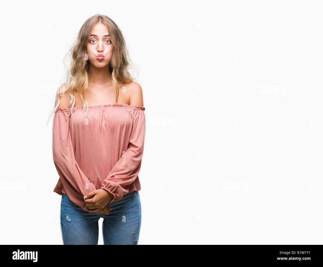 Beautiful young blonde woman over isolated background puffing cheeks ...