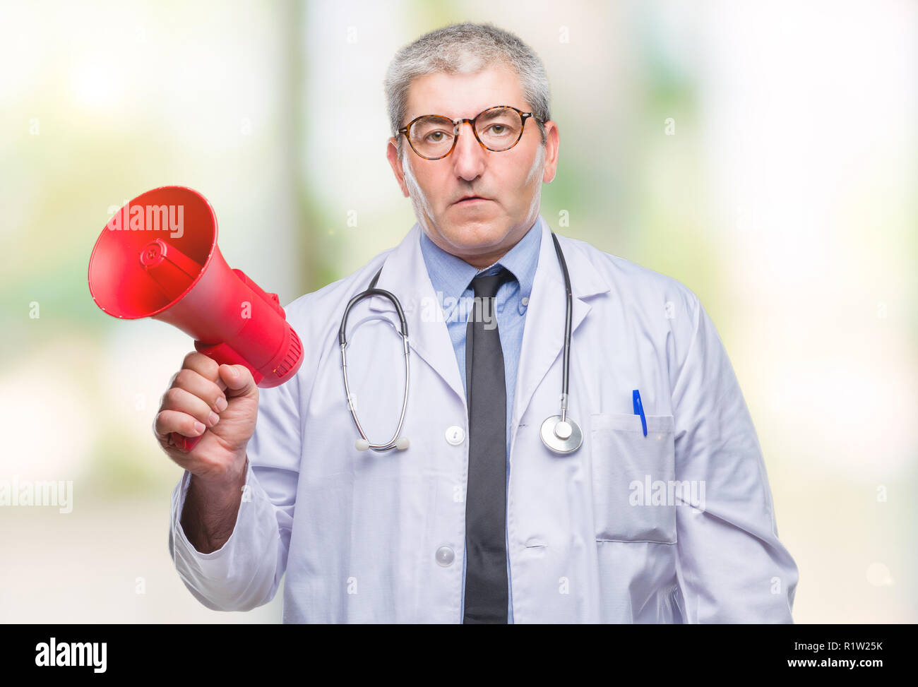 Handsome senior doctor man yelling through megaphone over isolated ...