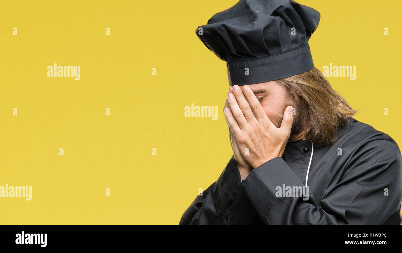 Young handsome cook man with long hair over isolated background with ...