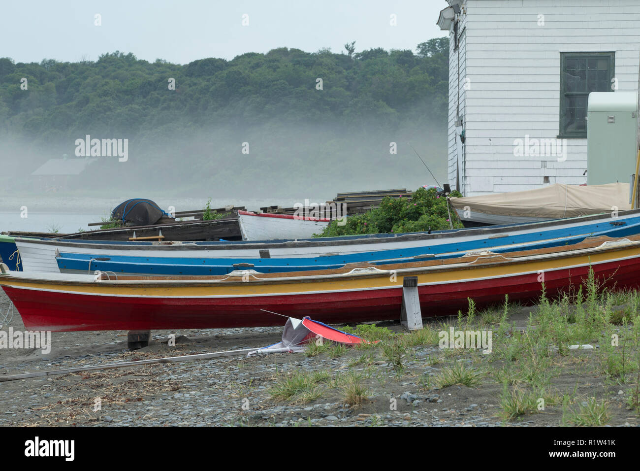 Colorful skiffs along rocky shore in Hull, Mass, a fishing community of ...