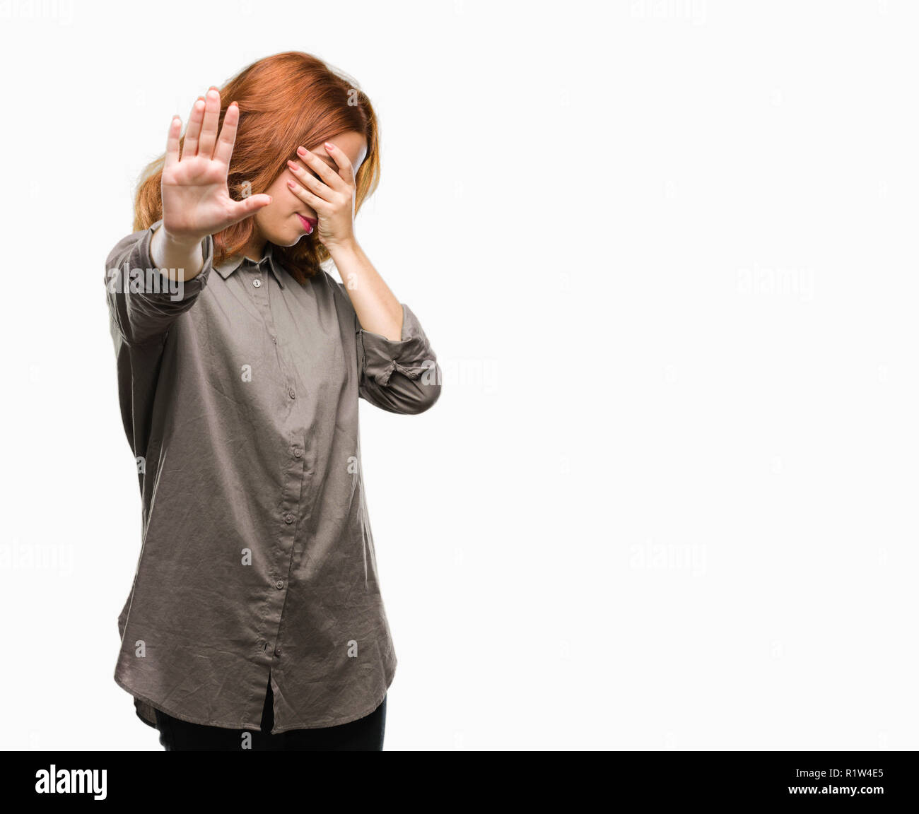 Young beautiful woman over isolated background covering eyes with hands ...