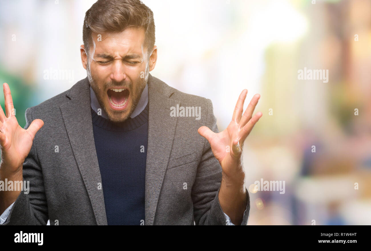 Young handsome business man over isolated background celebrating mad and crazy for success with ...