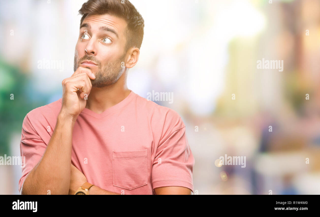 Young handsome man over isolated background with hand on chin thinking ...