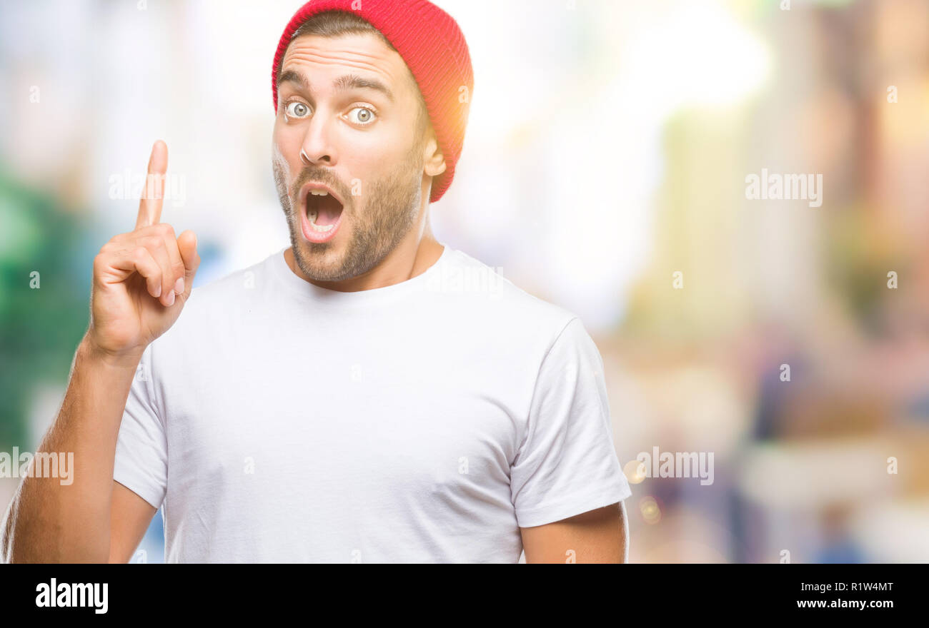 Young handsome man over isolated background pointing finger up with ...