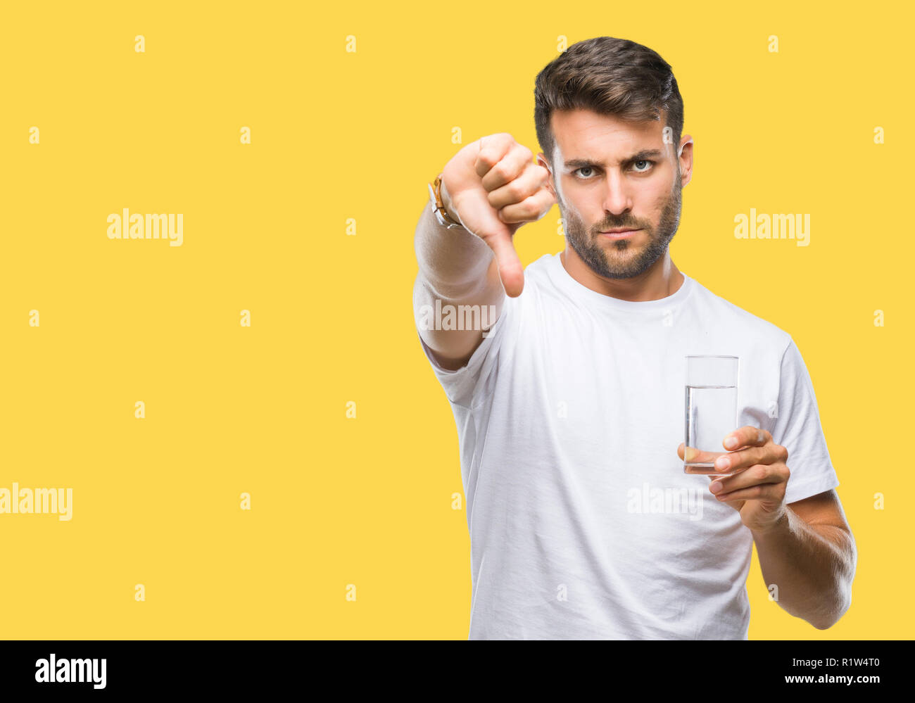 Young handsome man drinking glass of water over isolated background ...