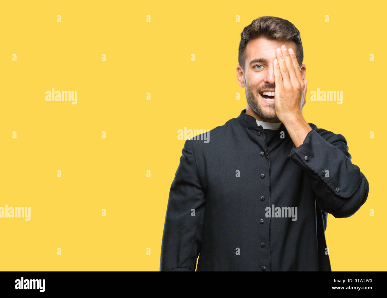Young catholic christian priest man over isolated background covering ...