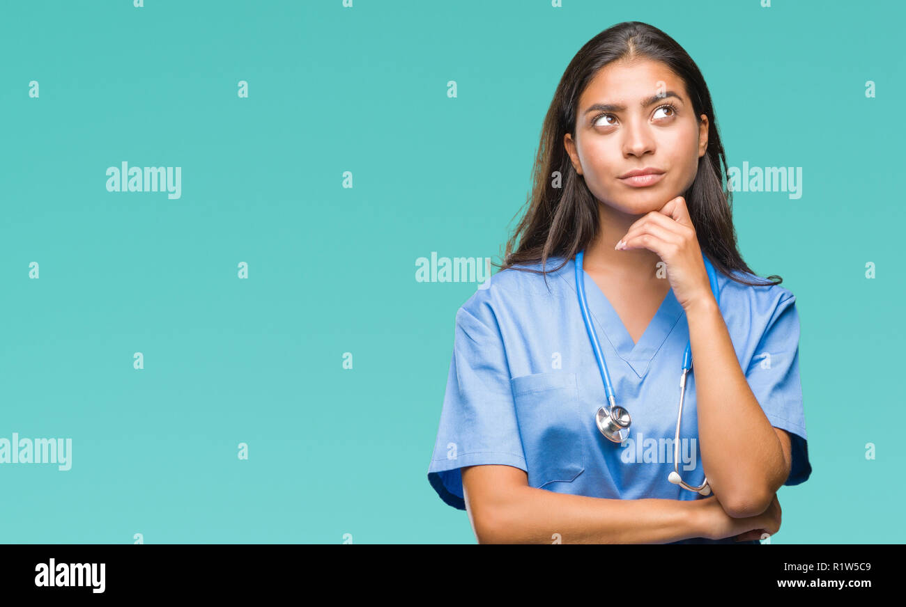 Young arab doctor surgeon woman over isolated background with hand on ...