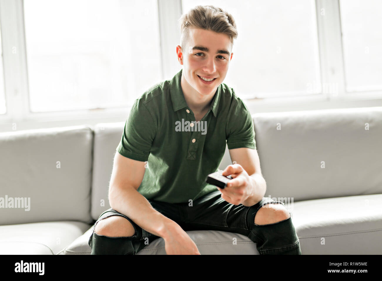 A guy with remote control watching TV Stock Photo - Alamy