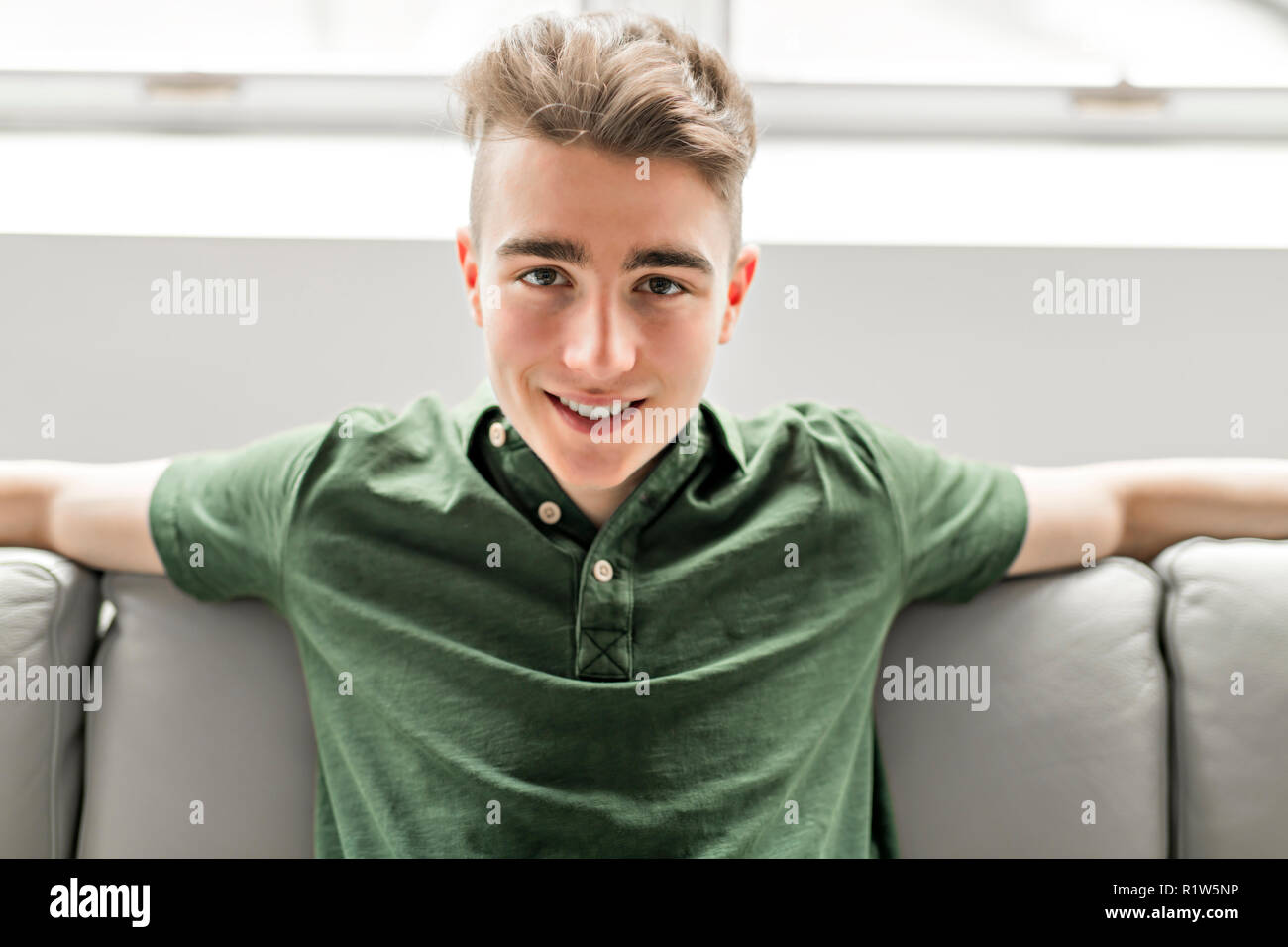 A Handsome confident young man relaxing at home on the sofa Stock Photo ...