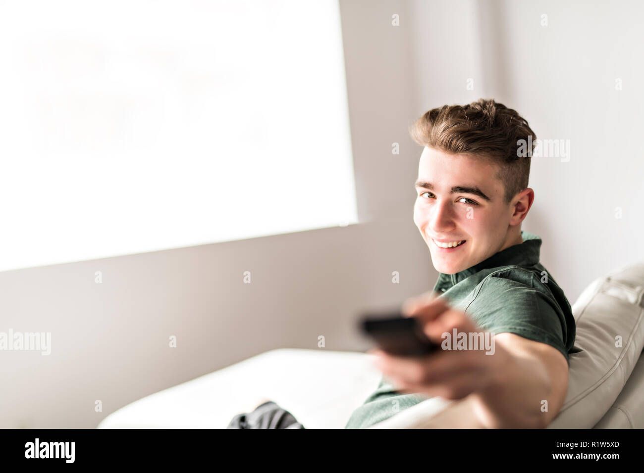 A guy with remote control watching TV Stock Photo - Alamy
