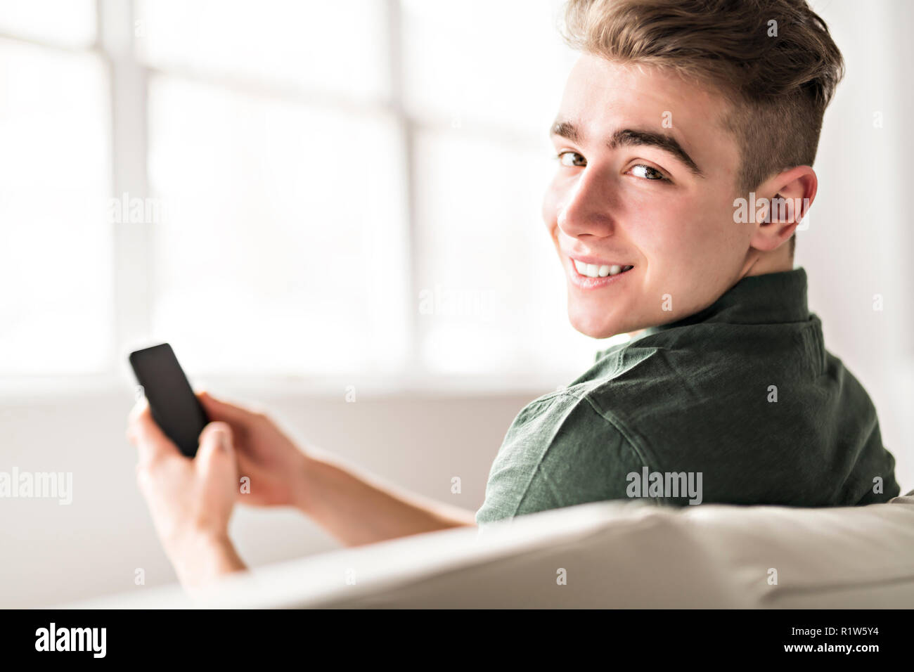 A nice Man texting on his couch and having fun Stock Photo - Alamy