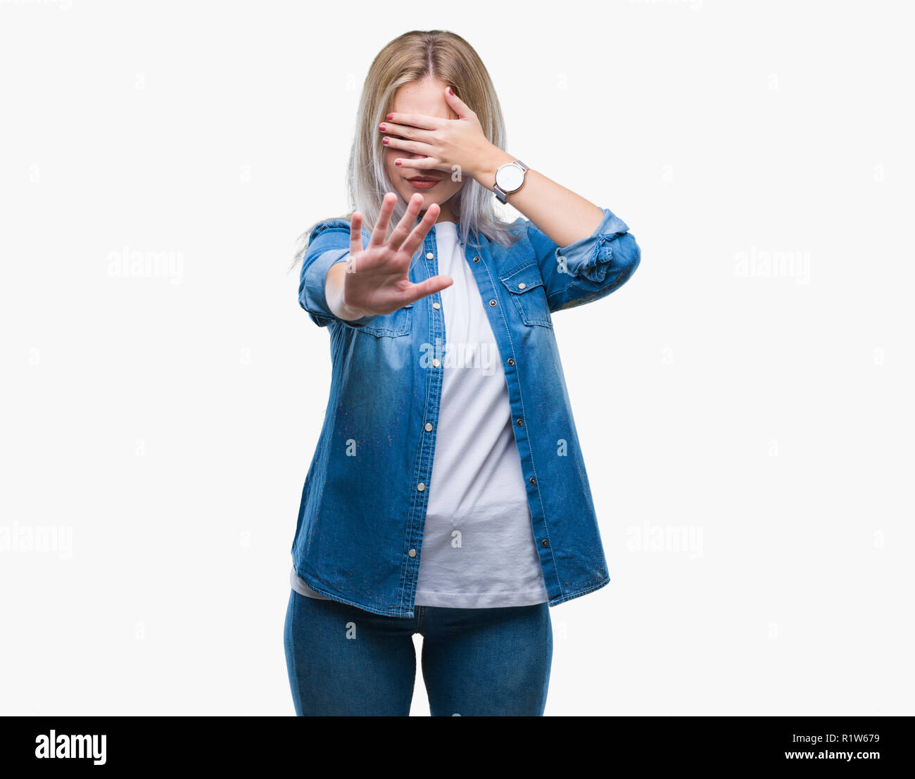 Young blonde woman over isolated background covering eyes with hands ...
