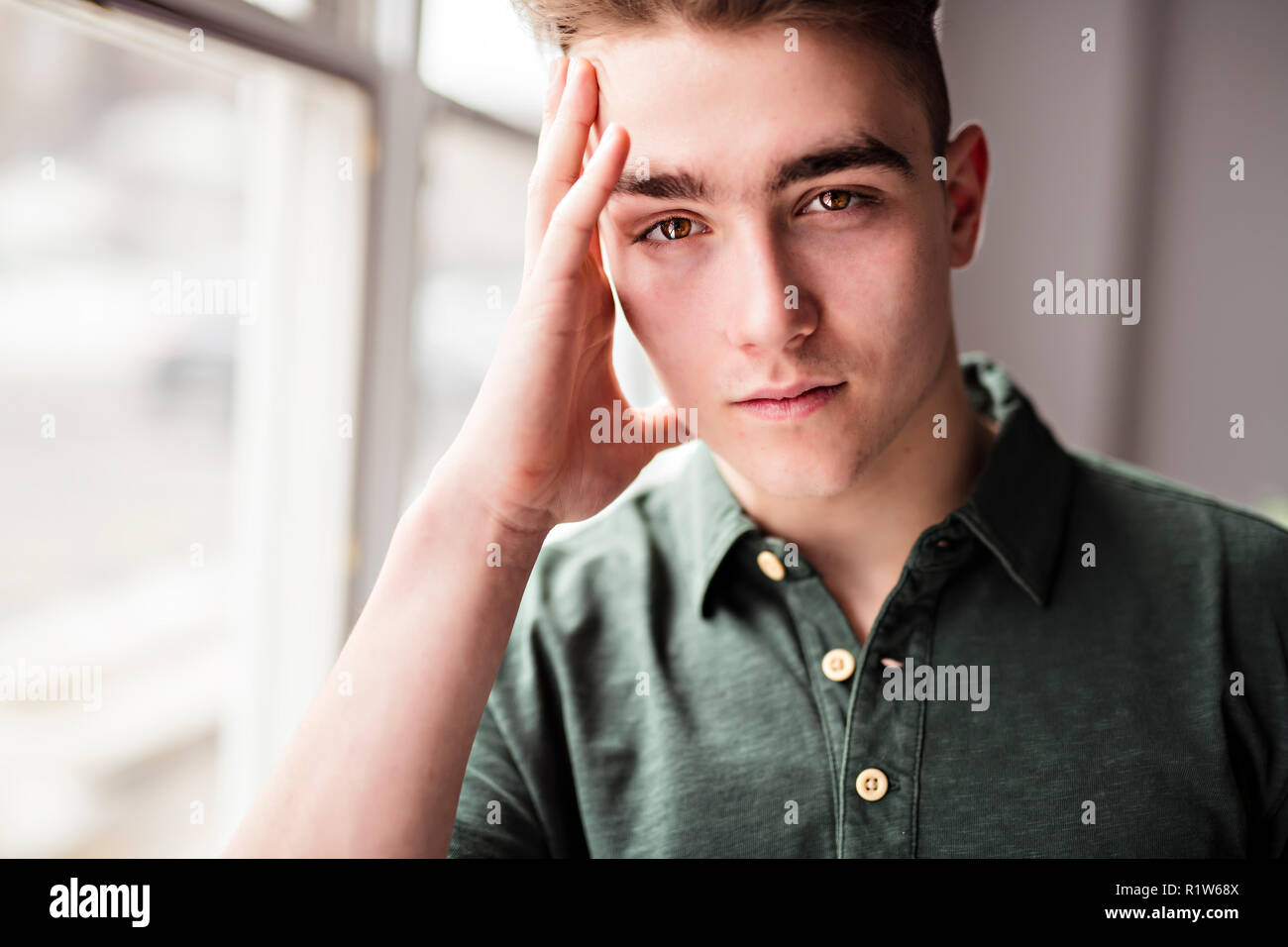 A man close to a window looking sad Stock Photo - Alamy