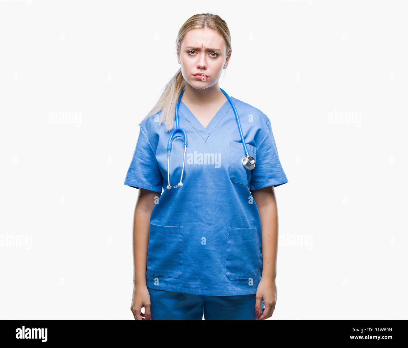 Young blonde surgeon doctor woman over isolated background skeptic and ...