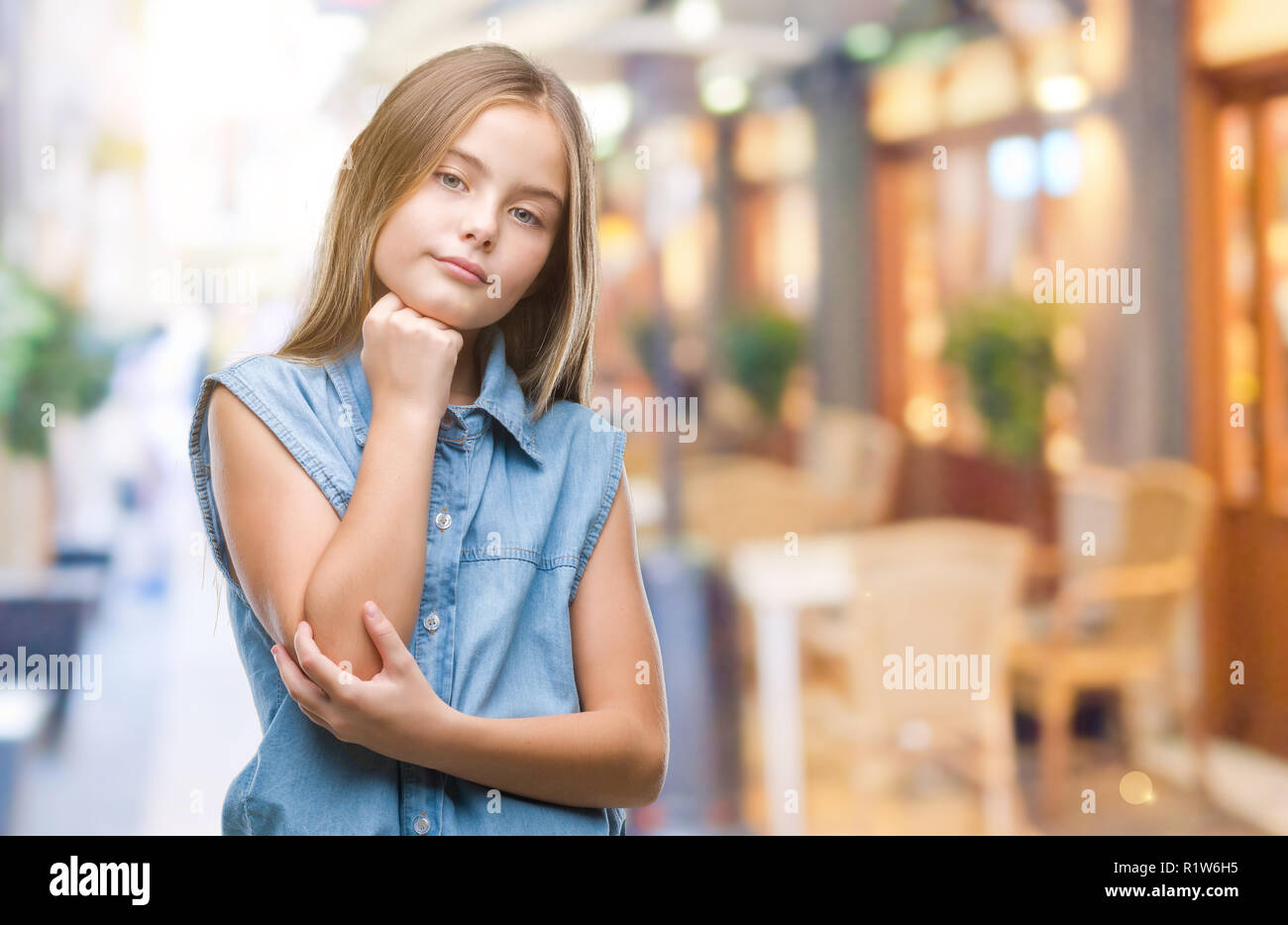 Young beautiful girl over isolated background with hand on chin ...