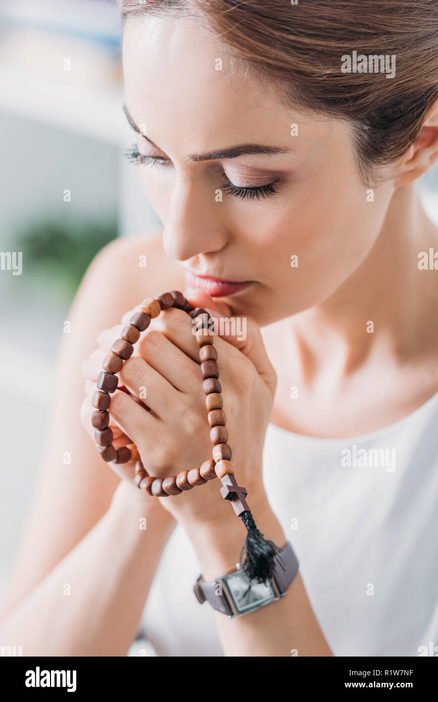 beautiful woman praying with wooden rosary beads Stock Photo - Alamy