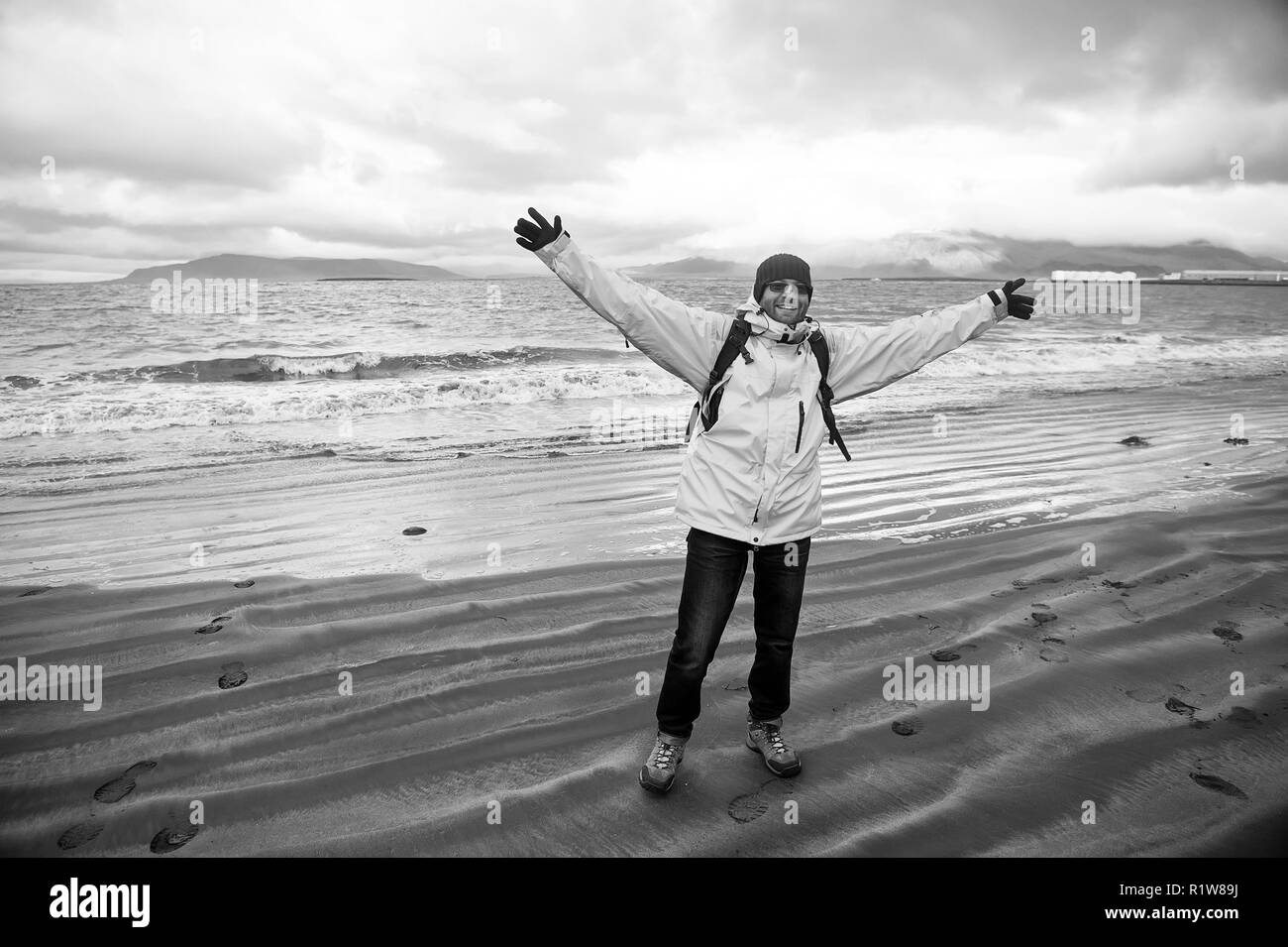 Happy man on sea beach in reykjavik, iceland. Man traveler smile with ...