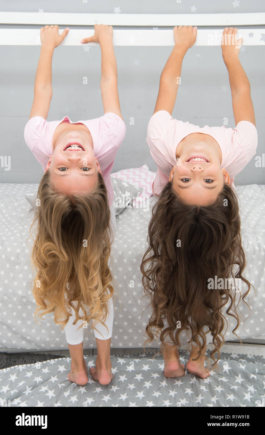 Little girls with long blond hair hang upside down. Hair salon for kids ...